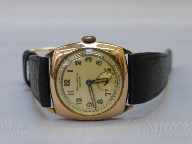A 9ct gold wrist watch with leather strap, marked Bravingtons London to ...