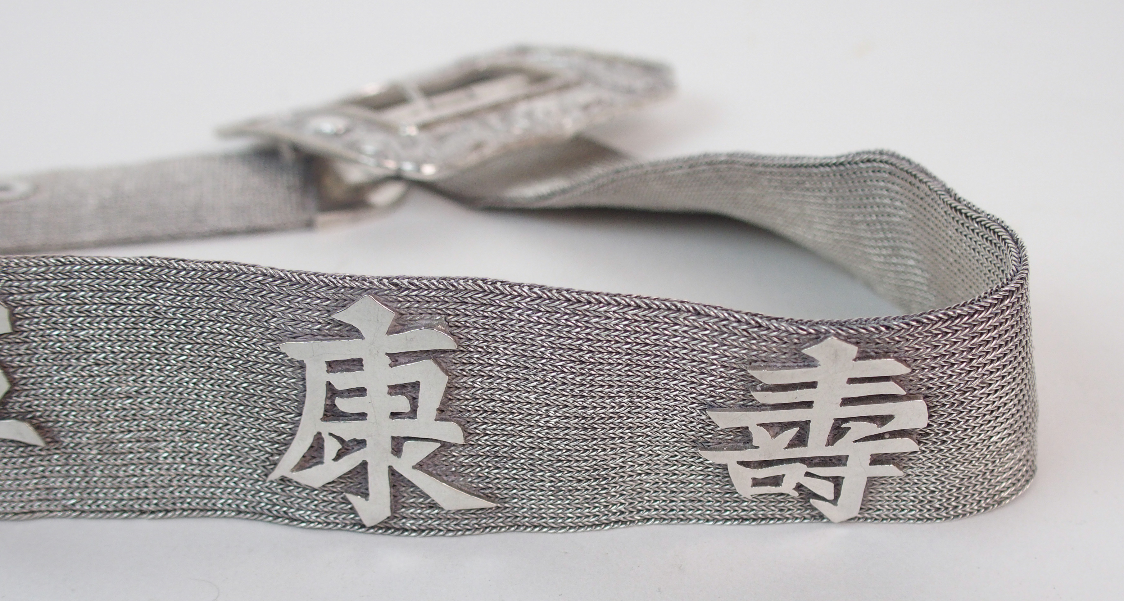A Chinese silver mesh belt applied with shou characters, the buckle ...