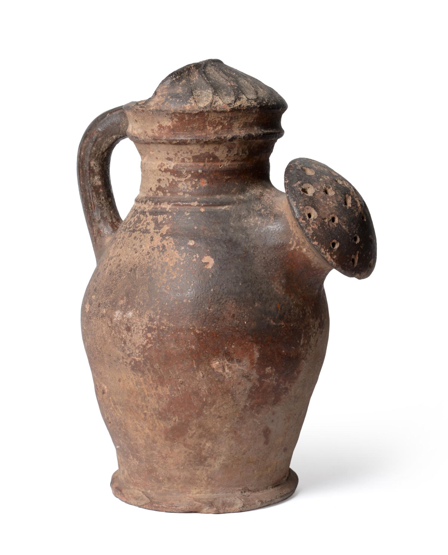 A Terracotta Watering Can, 16th century, of baluster form with pierced ...