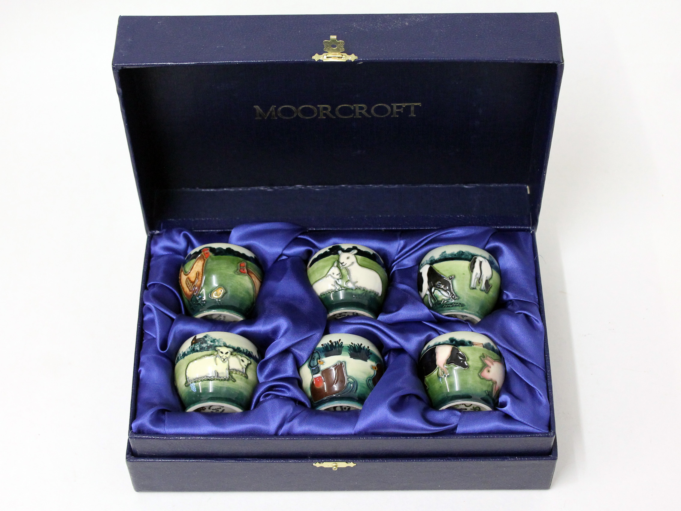A set of six Moorcroft pottery egg cups each decorated with farm yard ...