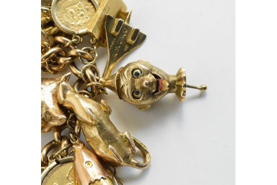 An exceptionally large 9ct gold charm bracelet set with numerous ...