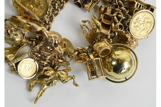 An exceptionally large 9ct gold charm bracelet set with numerous ...