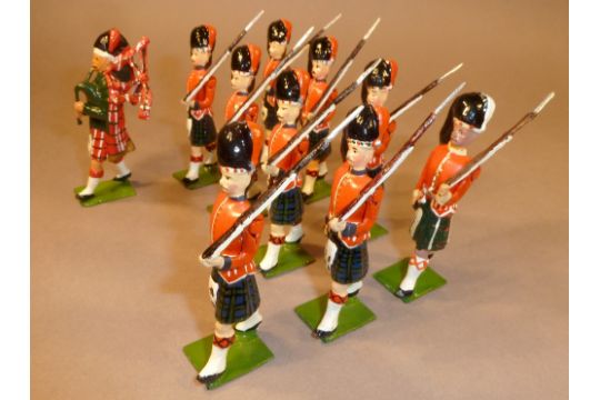 Highlanders marching at the slope eight Black Watch with piper, drummer ...
