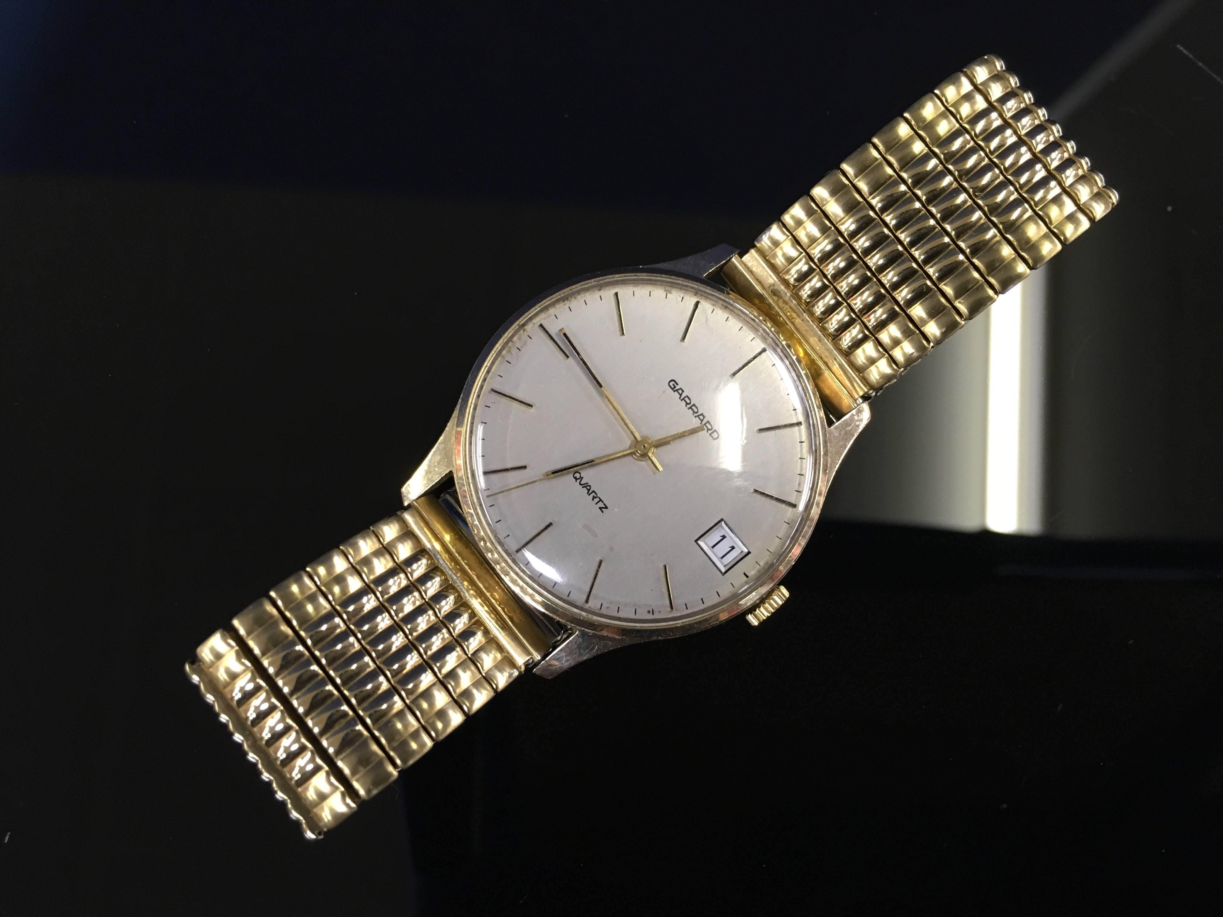 9CT. GOLD GARRARD GENTS QUARTZ WRIST WATCH ON YELLOW METAL BRACELET