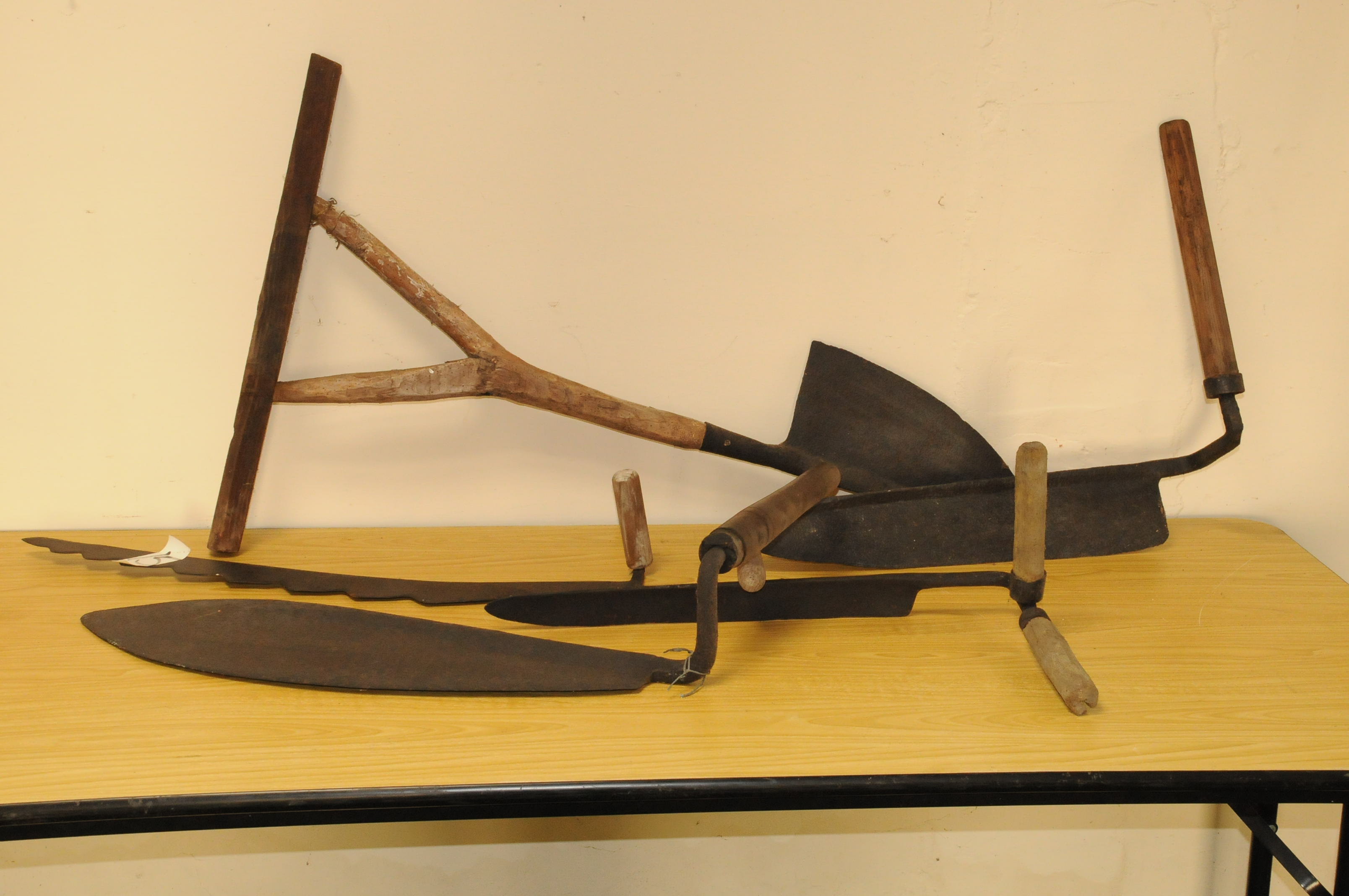 A group of five vintage hand cutting tools, including a peat cutter, a ...