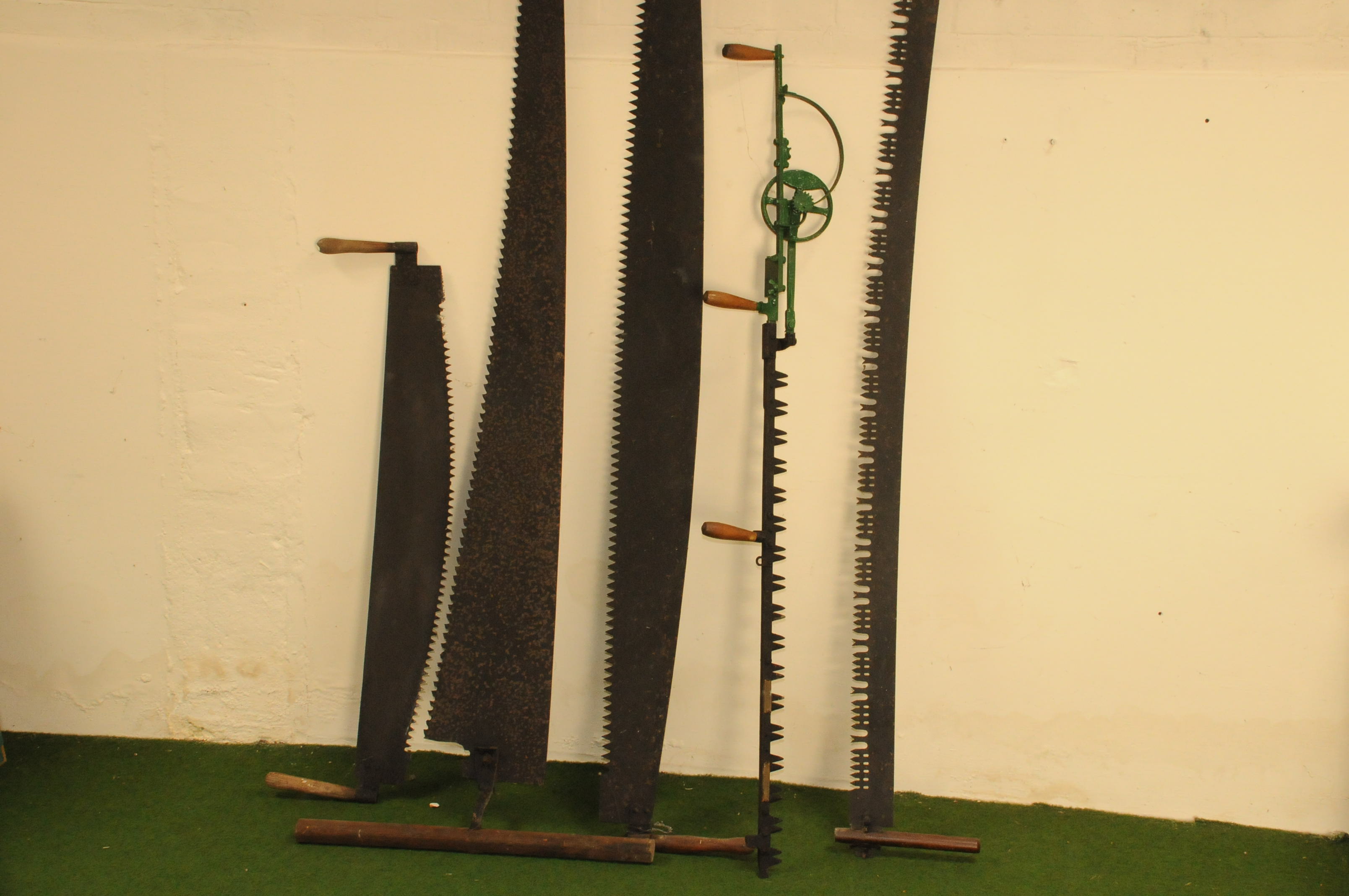 A group of four antique wood cutting saws and a hedge trimmer, the hand ...