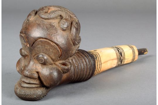 A Cameroon pottery and bone pipe the bowl modelled as a head with beard ...