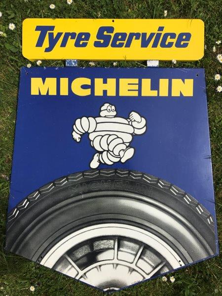 A Michelin aluminium sign depicting Mr. Bibendum running on top of a ...