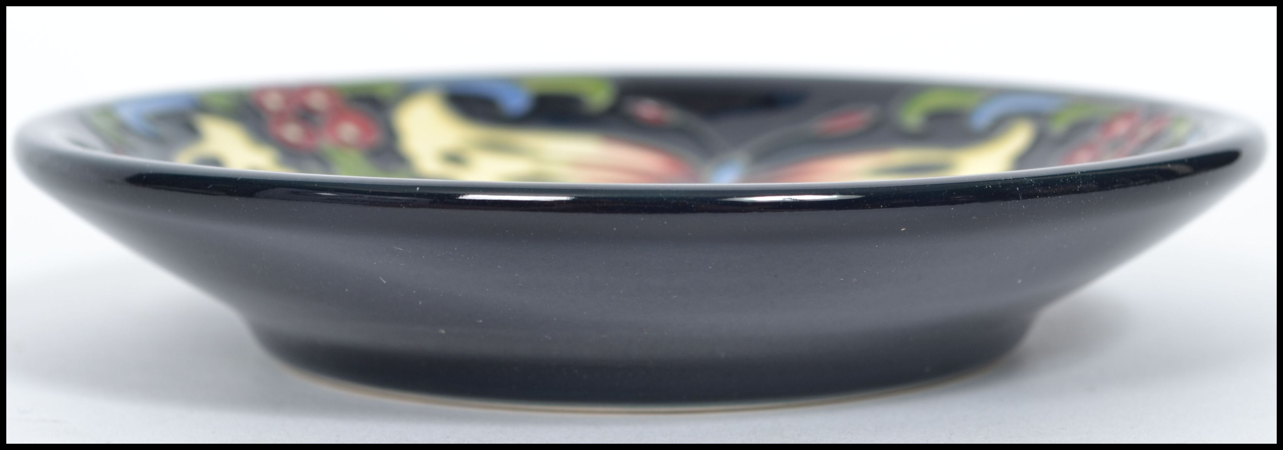 A Moorcroft ceramic tube lined coaster pin dish decorated in the Burley ...