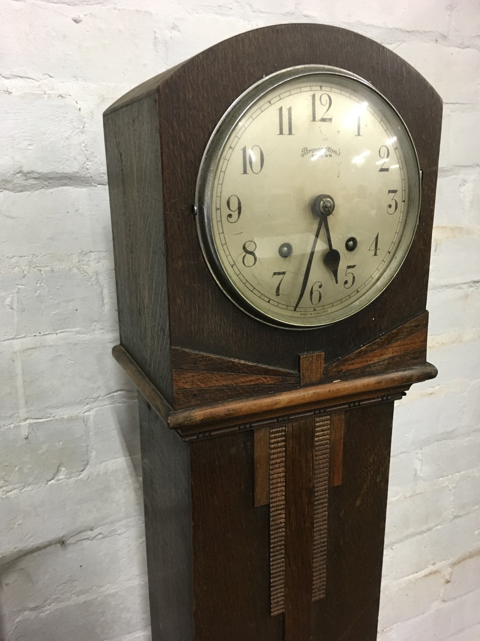 A deco oak cased grandmother clock, the Bravingtons Ltd silvered dial ...