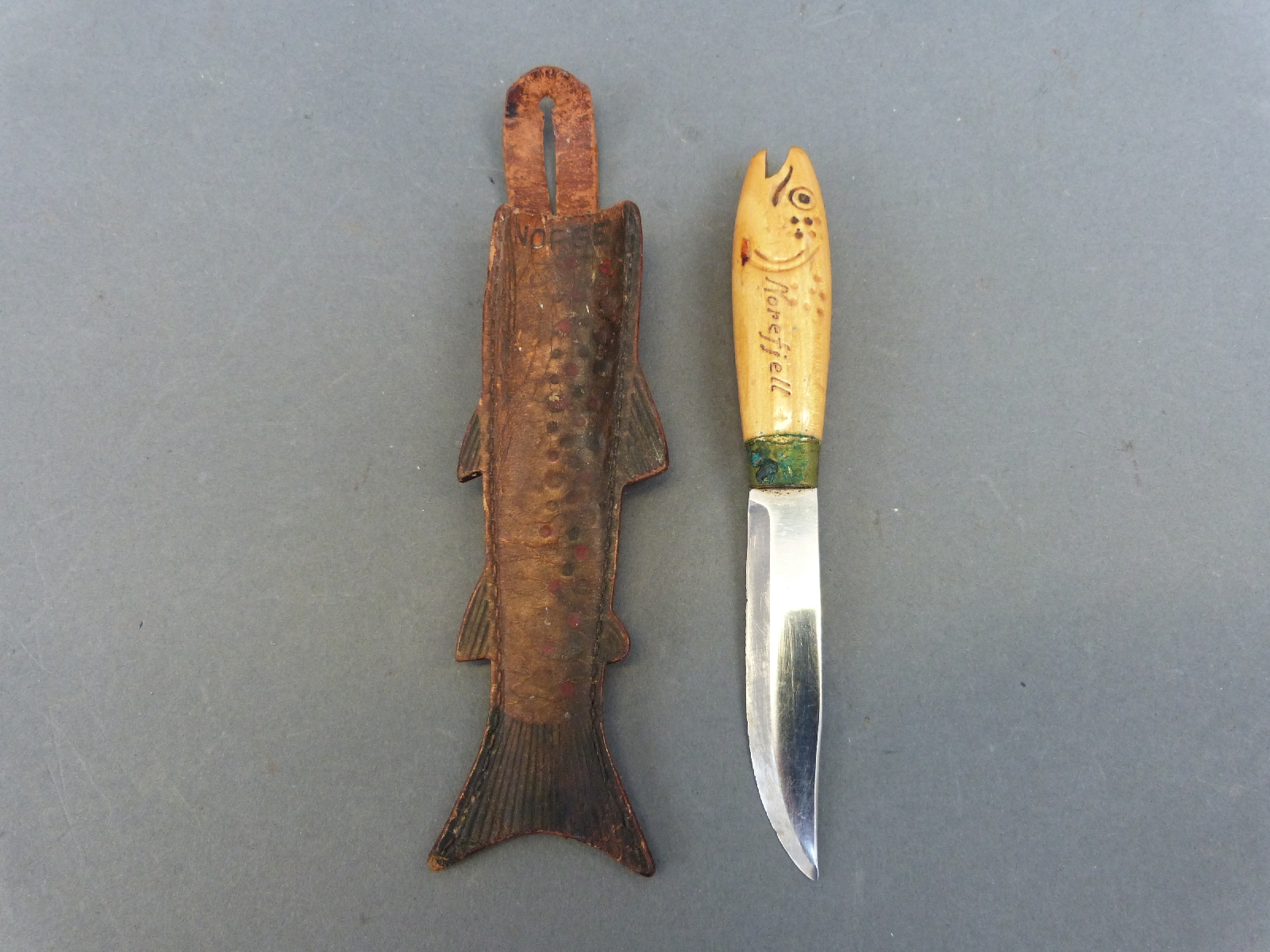 A carved figural fish knife marked OYO Geilo Rustfri to blade and ...