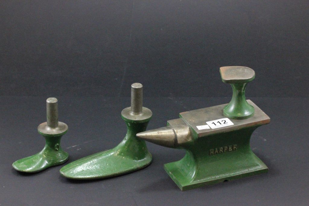 A small vintage iron anvil by Harper, with three small fitted shoe lasts