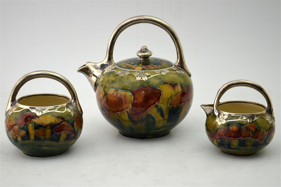 A William Moorcroft tea set trio 'Claremont' design, silver overlay by ...