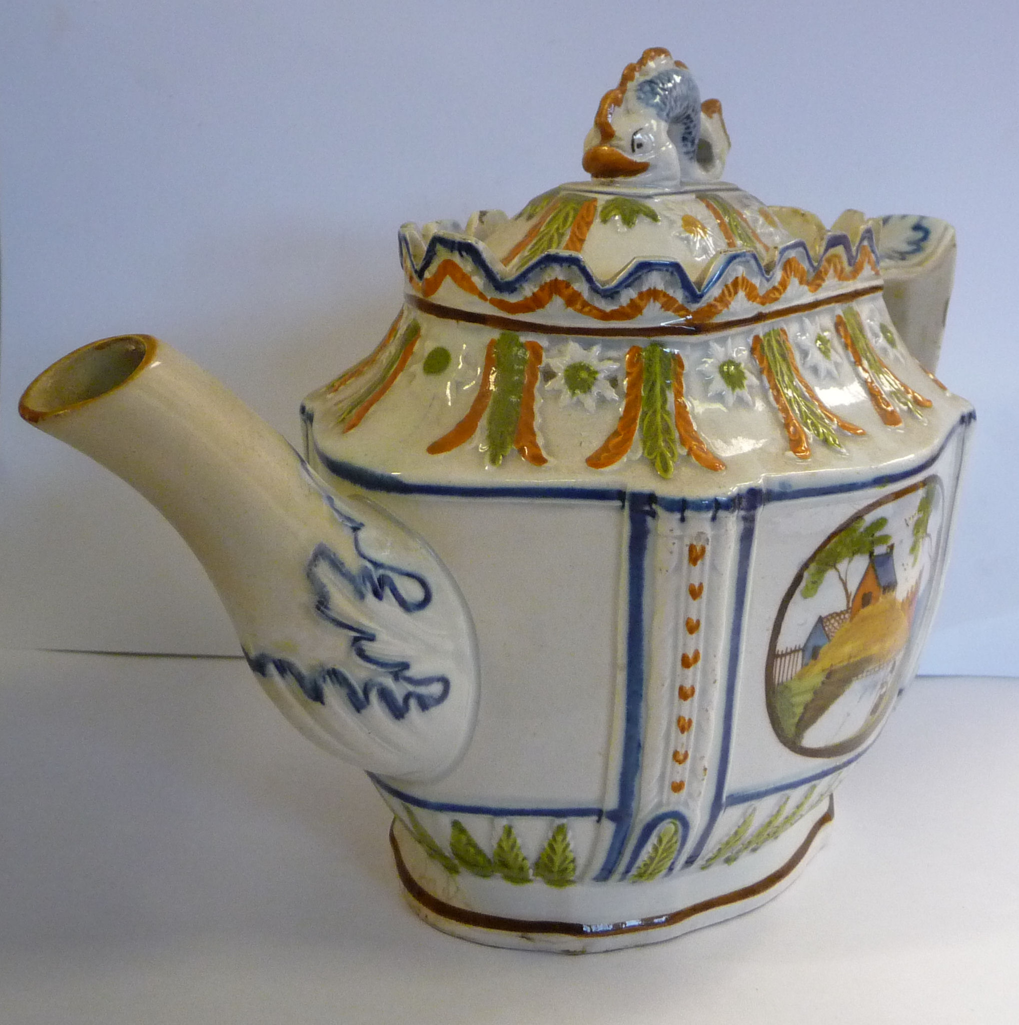 An early 19thC Prattware oval teapot with a lid and dolphin finial ...