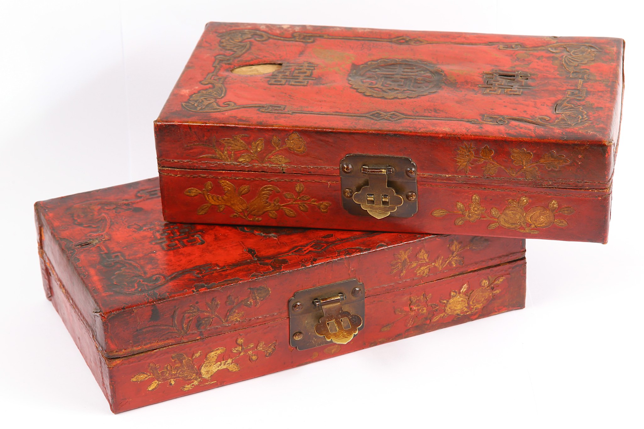 A pair of Chinese red lacquered leather hinged boxes, decorated with ...