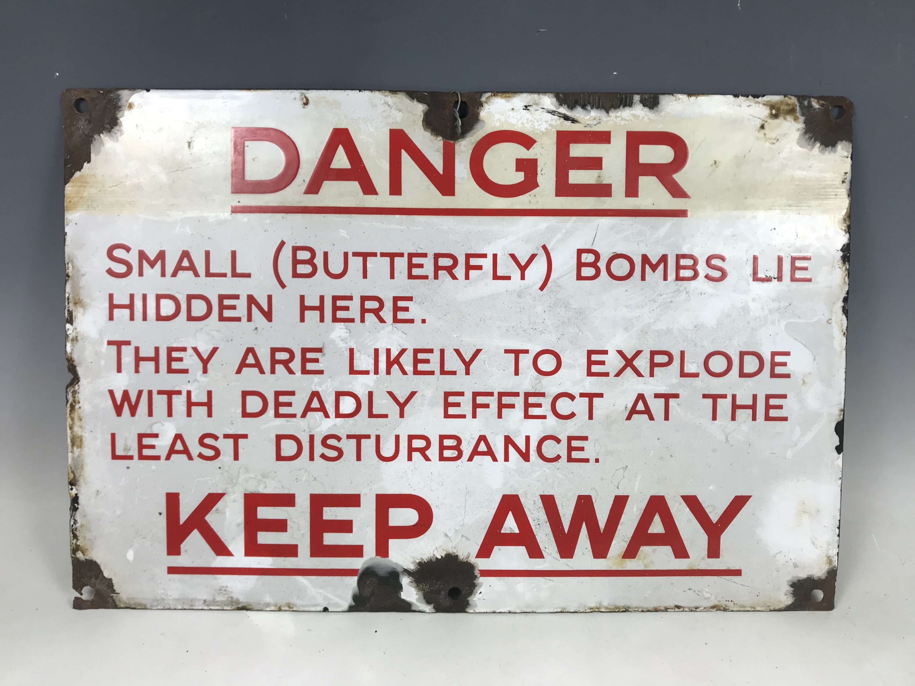 A Butterfly bomb enamel warning sign, 30 cm x 47 cm