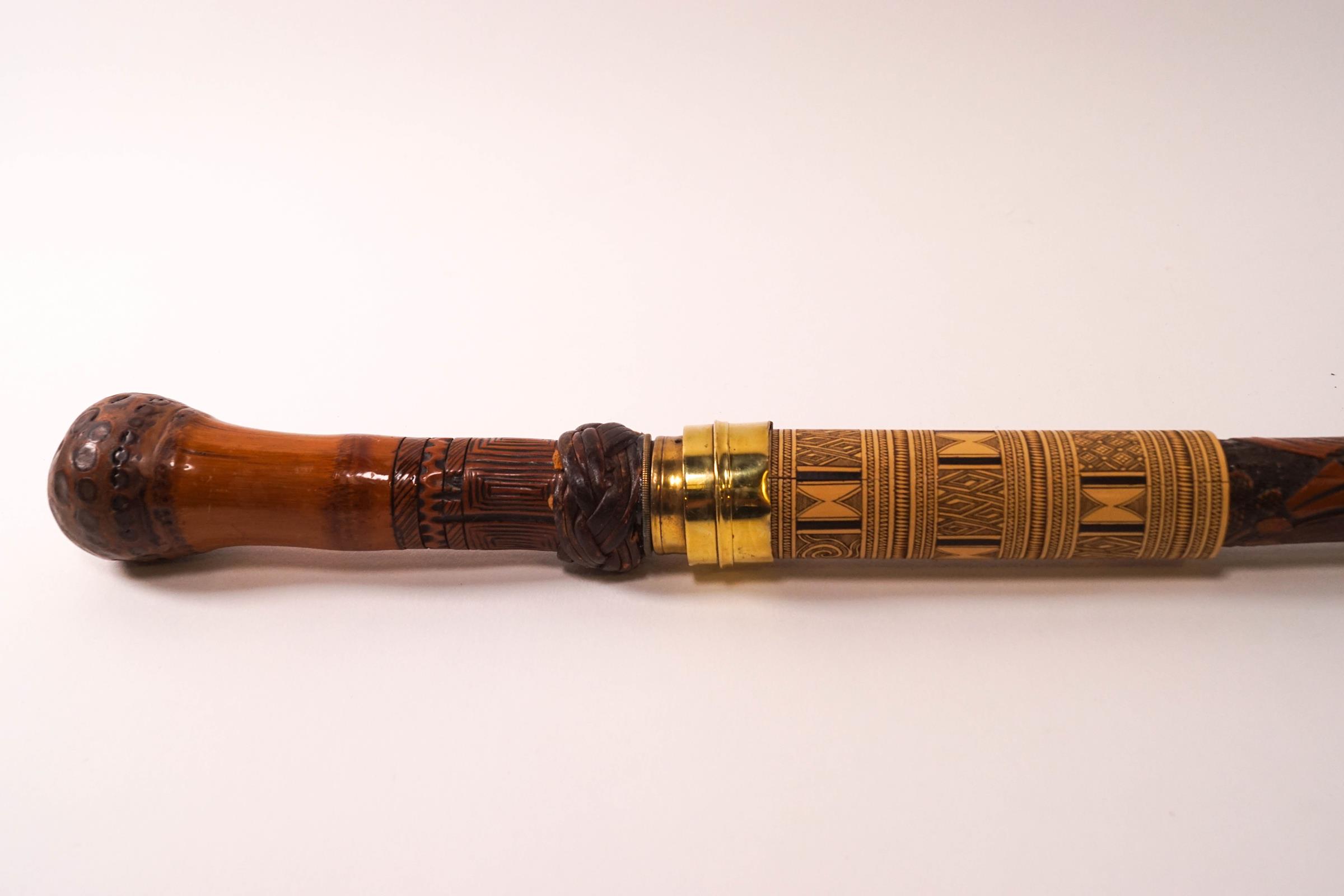 A Japanese bamboo sword stick, the sheath carved with warriors