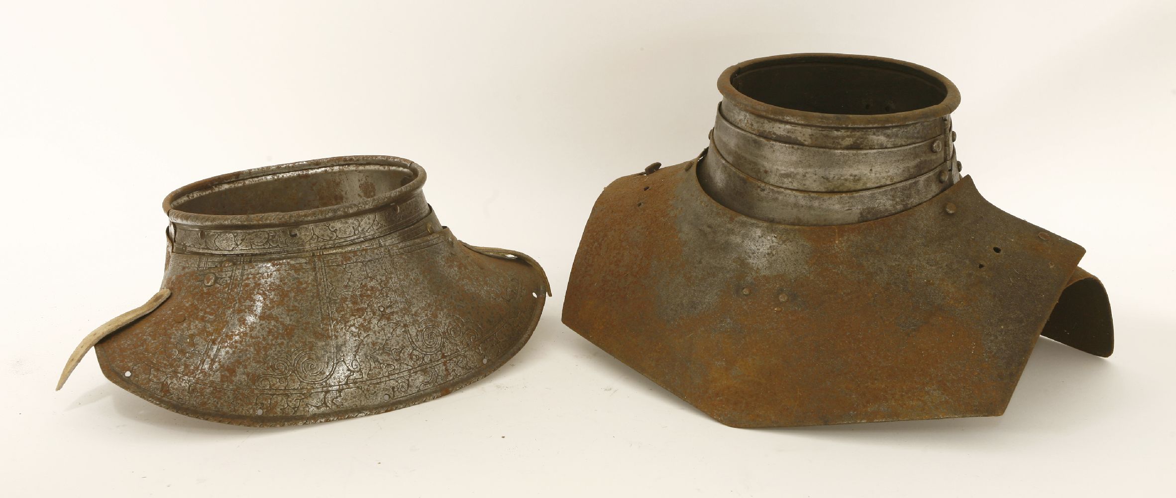 Two gorgets,16th century, one with etched decoration, the other plain ...