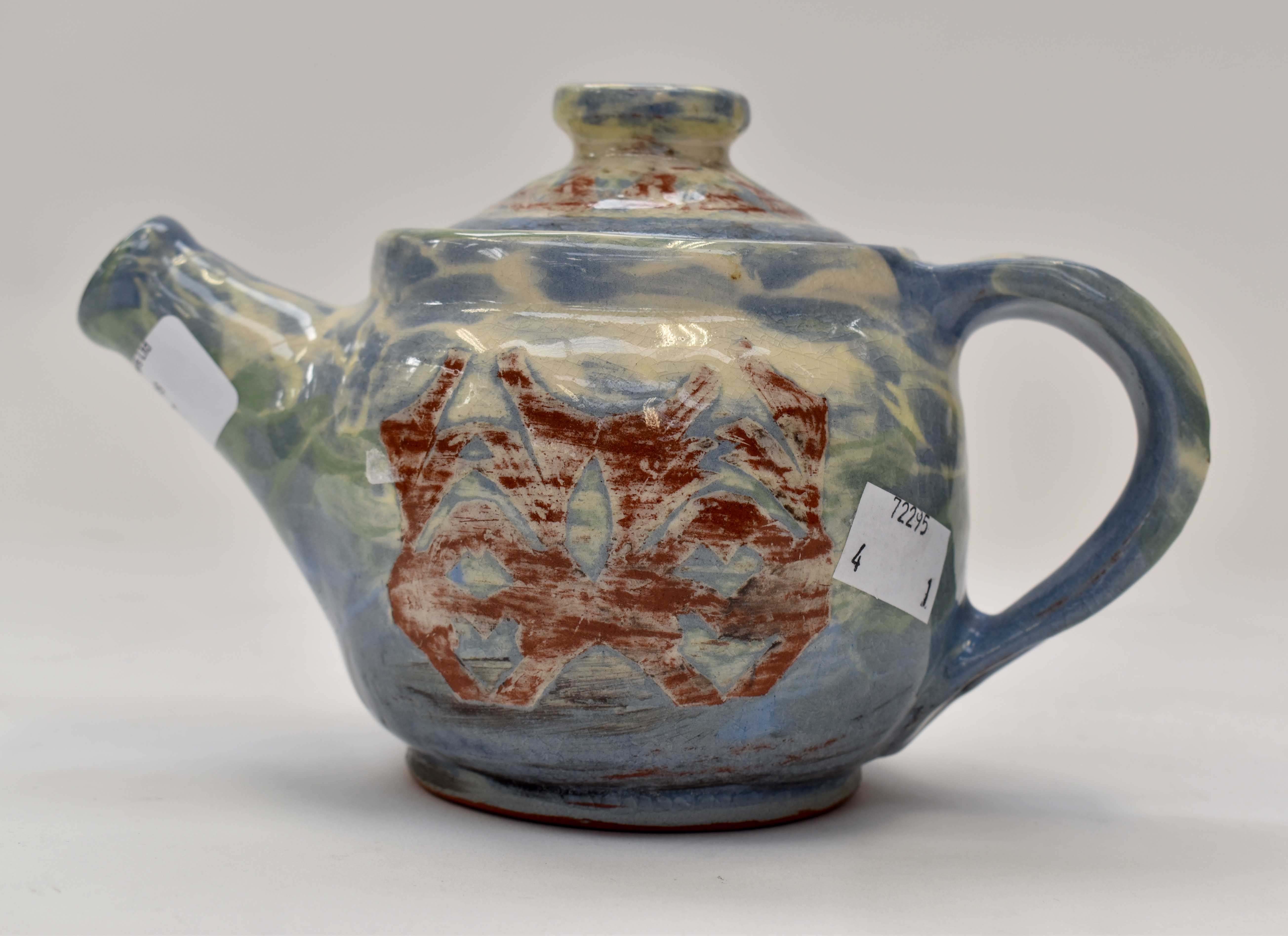 A Judith Trim teapot in a blue glaze, bearing makers stamp