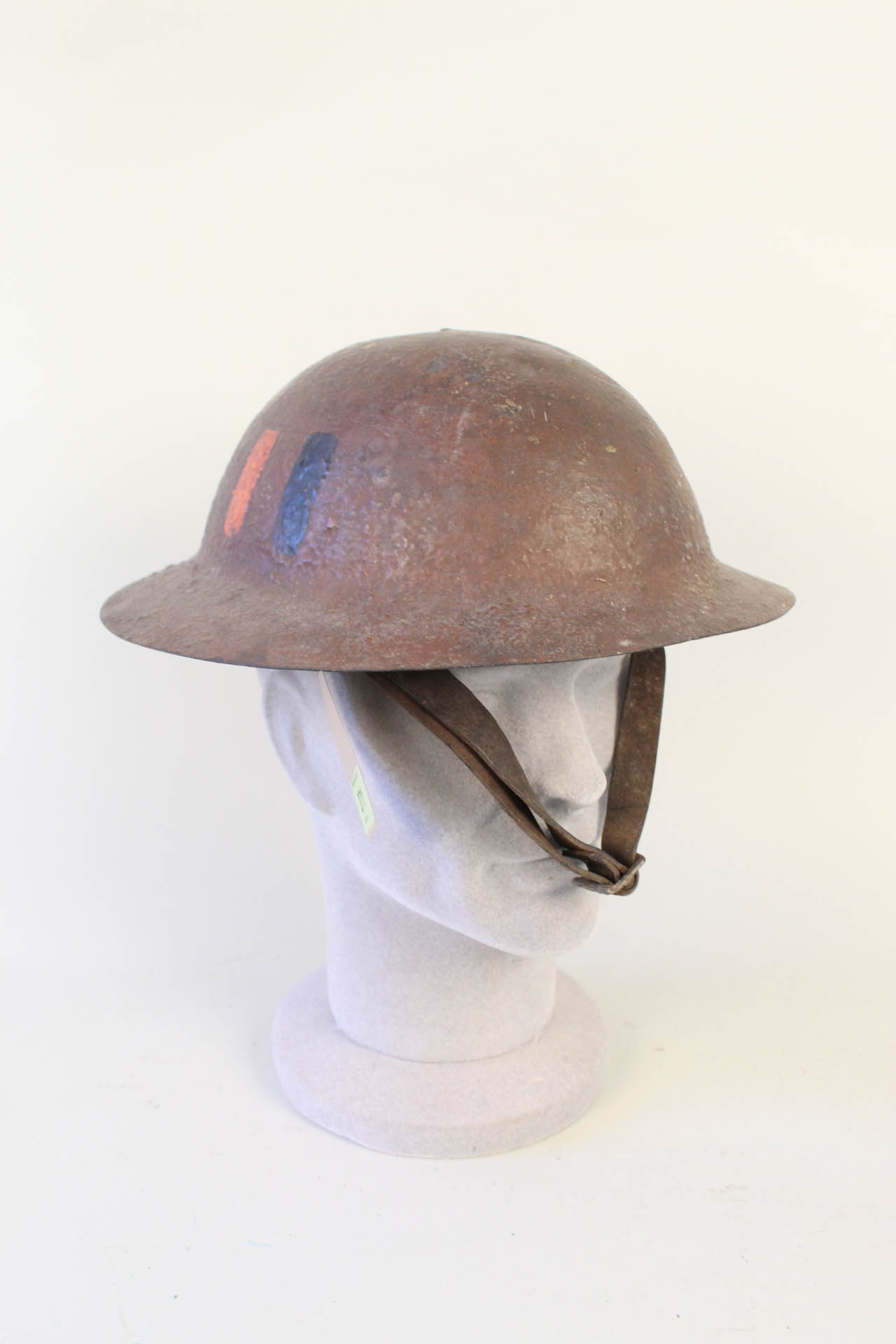 A WWI British 'Brodie' steel helmet, a MkI rimless example stamped on ...