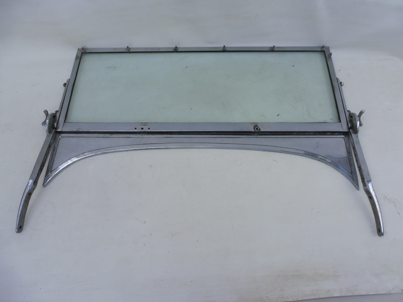 A chrome plated fold flat windscreen with supporting brackets ...