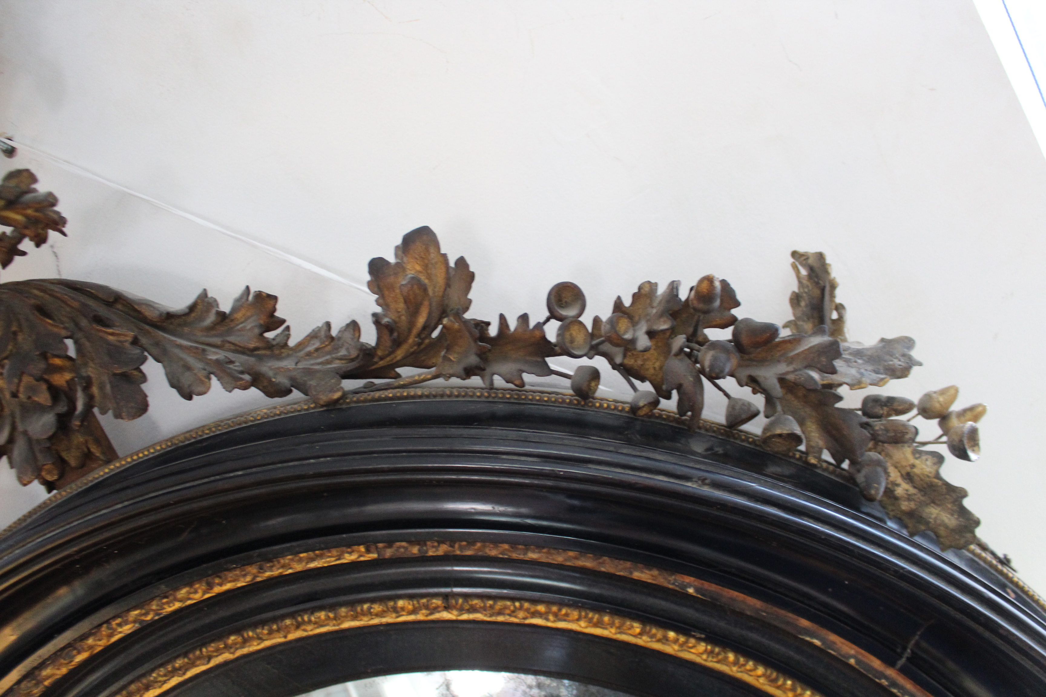 A REGENCY EBONISED & GILT-GESSO FRAME LARGE CONVEX WALL MIRROR, with ...