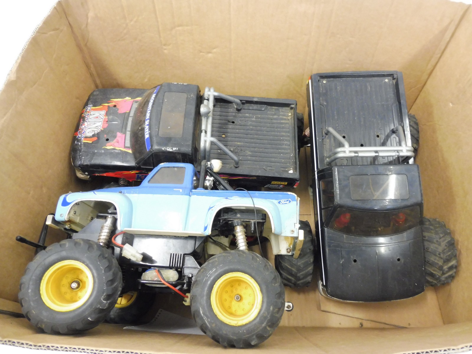 Three Tamiya 'Big Foot' remote controlled vehicles.