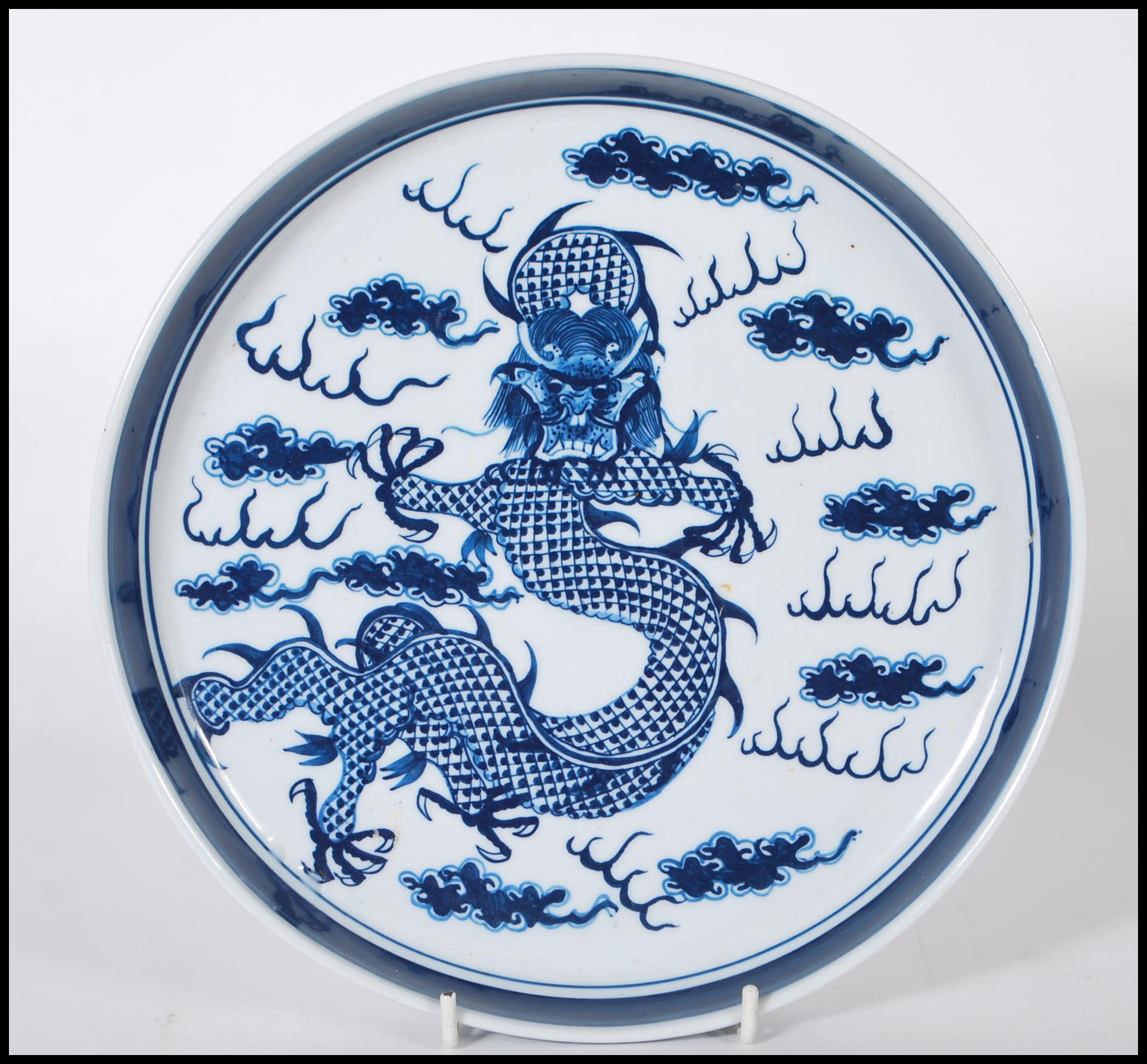 A 19th Century Chinese ceramic plate being hand painted in blue ...