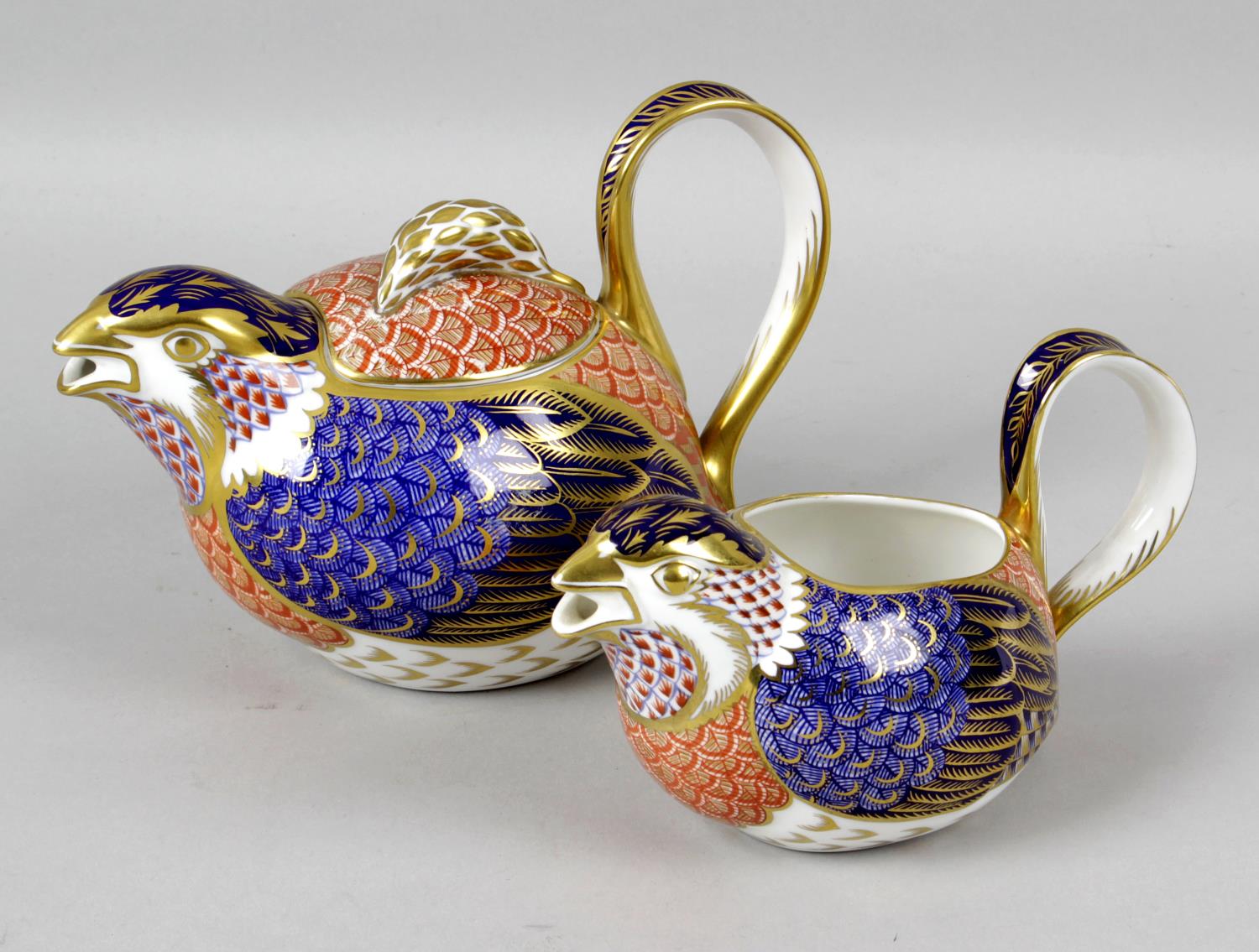A Royal Crown Derby tea pot, together with a cream jug, each modelled ...