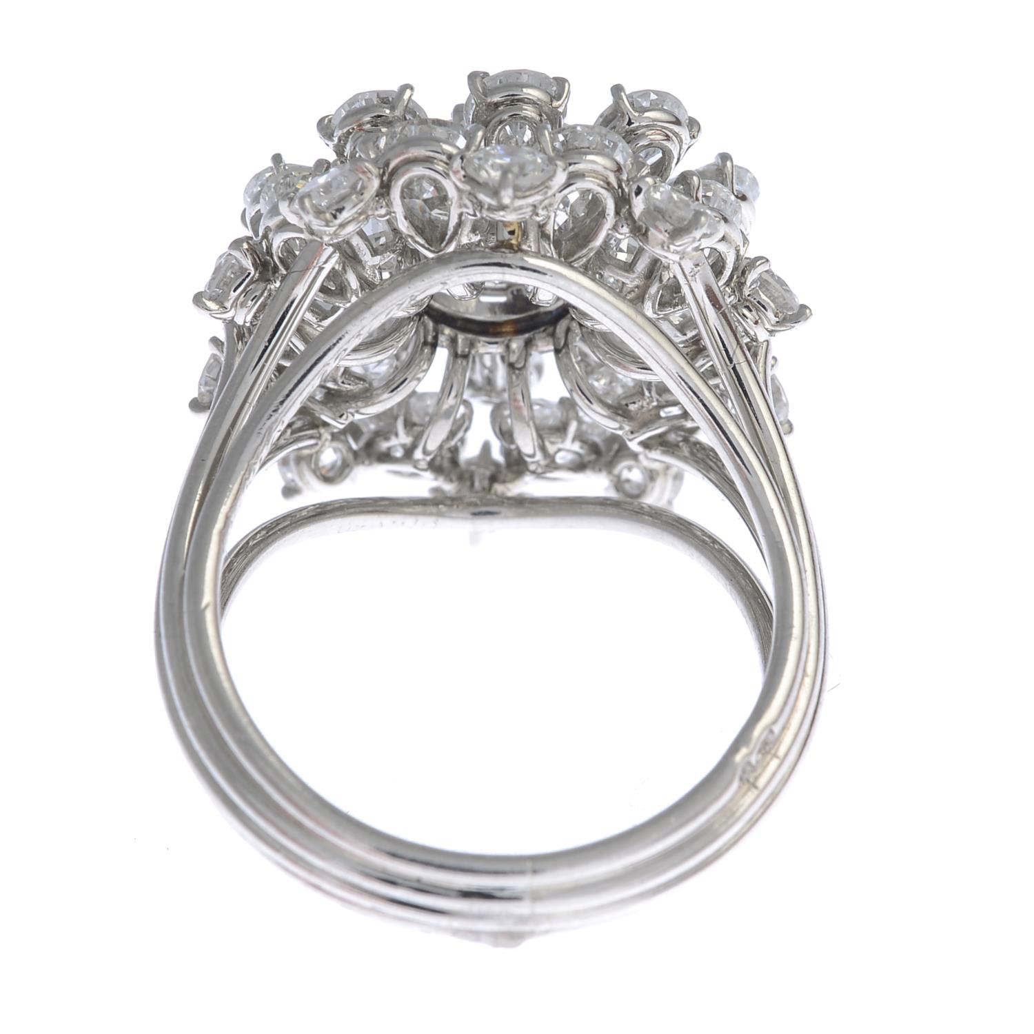 CARTIER - a platinum and 18ct gold diamond cluster ring. The brilliant ...