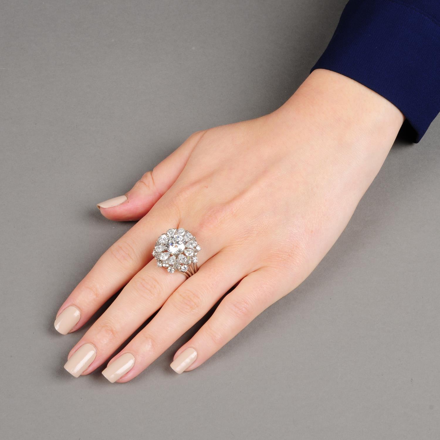 CARTIER - a platinum and 18ct gold diamond cluster ring. The brilliant ...