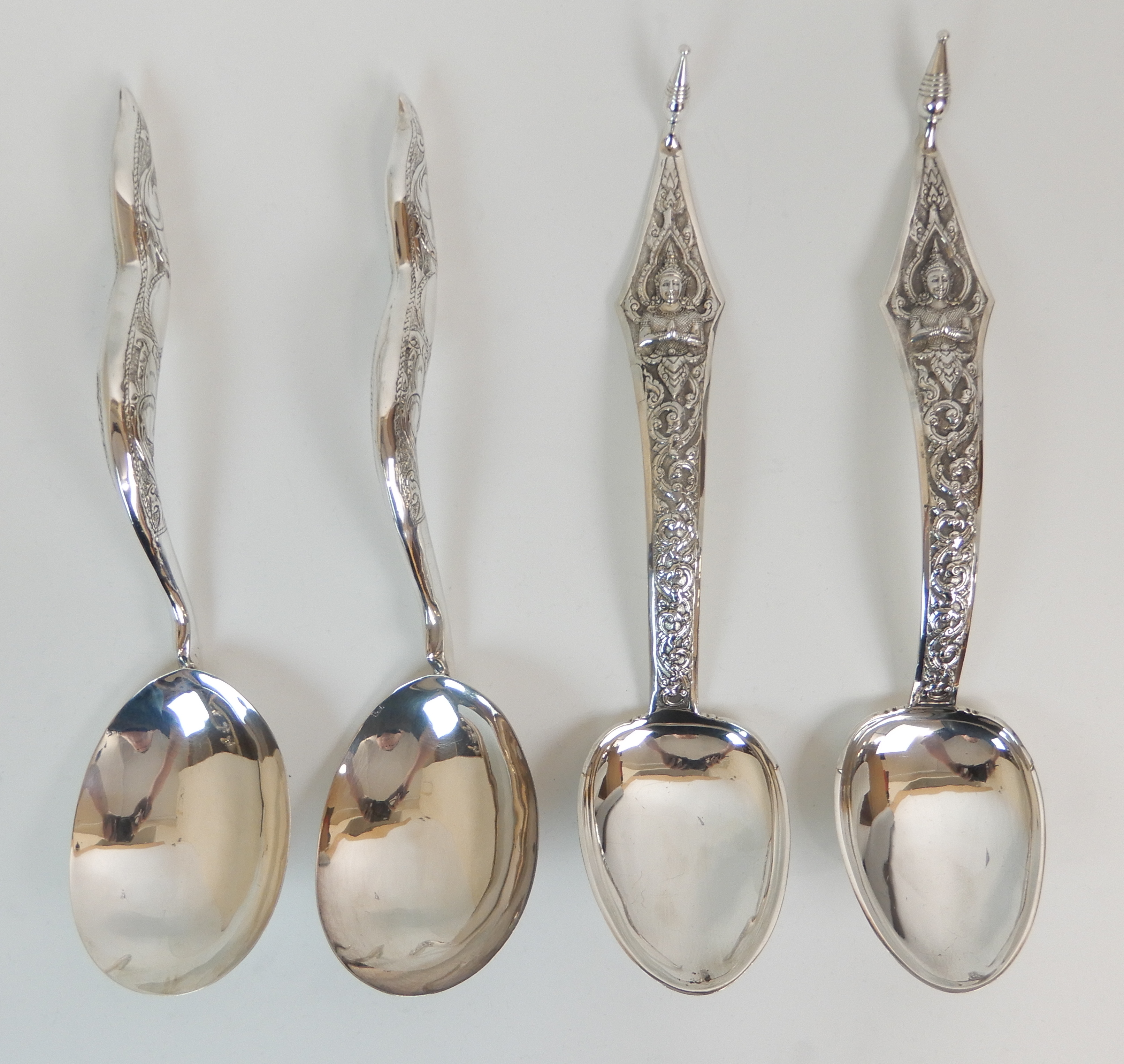 A PAIR OF EASTERN SERVING SPOONS marked Thailand sterling, the shaped ...