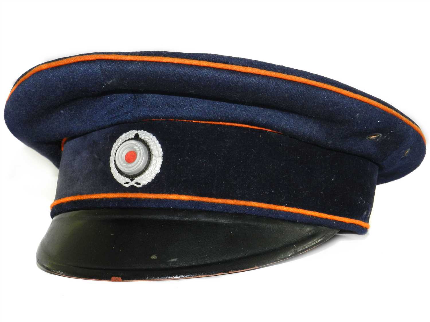 A German Third Reich Postal Worker’s visor cap constructed of dark blue ...