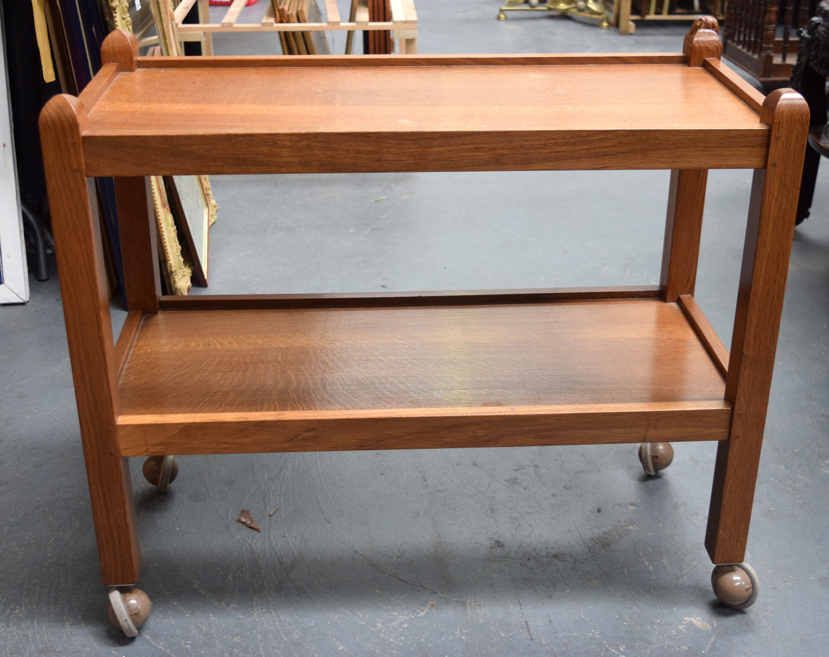A ROBERT MOUSEMAN THOMPSON TWO TEIR OAK TEA TROLLEY, formed with square ...
