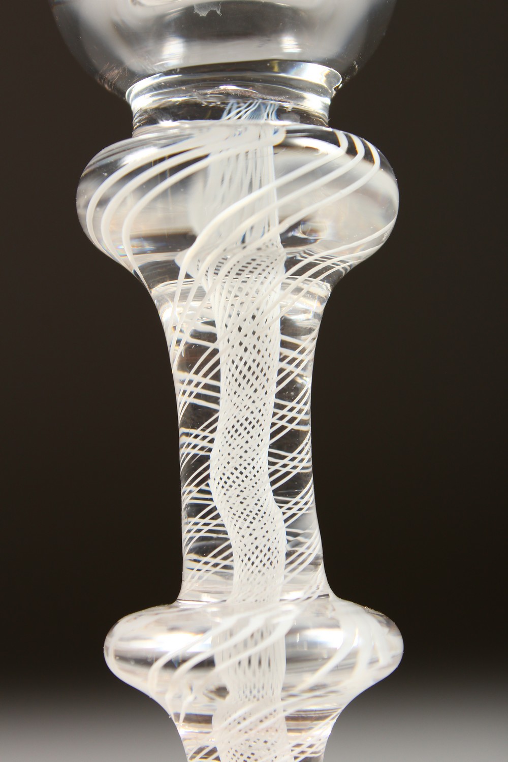 A GEORGIAN WINE GLASS with inverted bell shaped bowl and three knops to ...