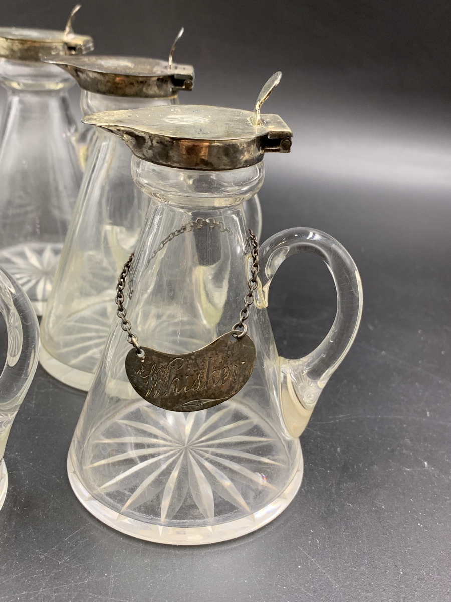 A SET OF SIX GLASS AND SILVER TOPPED WHISKEY TOTS WITH TWO ASSOCIATED ...
