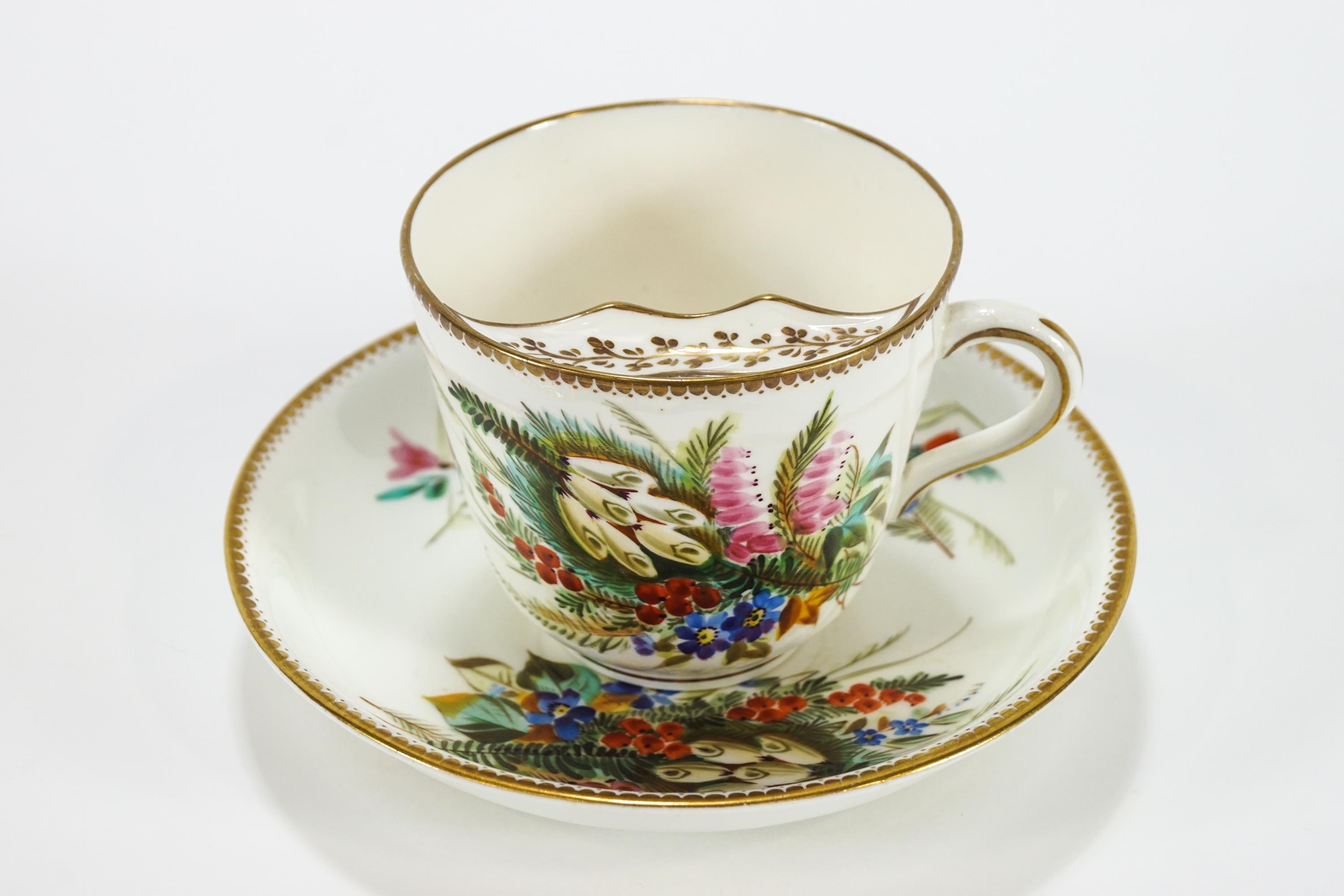 A 19th century porcelain moustache cup and saucer, painted in enamels ...
