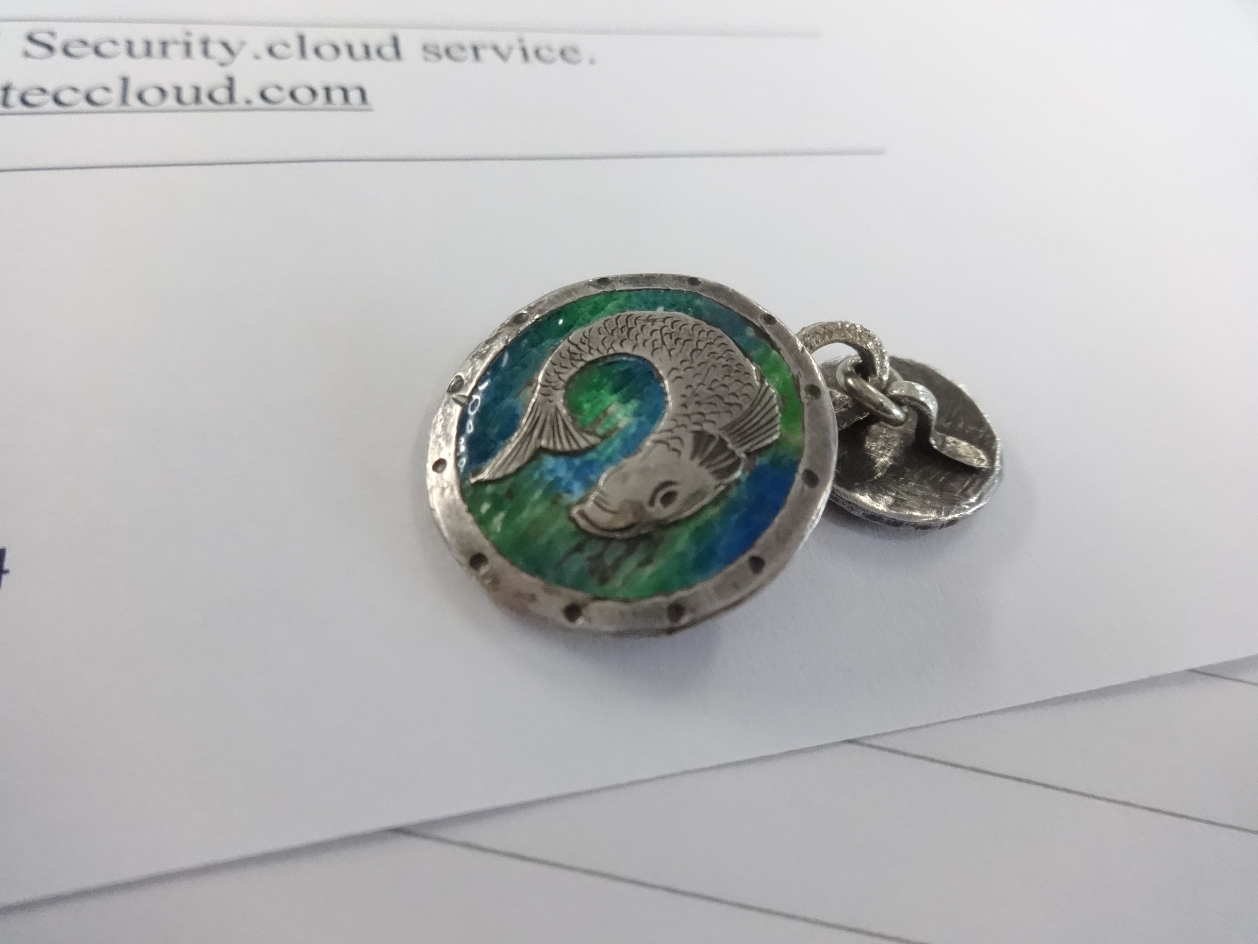 A pair of arts and crafts style enamel cufflinks each decorated with a ...