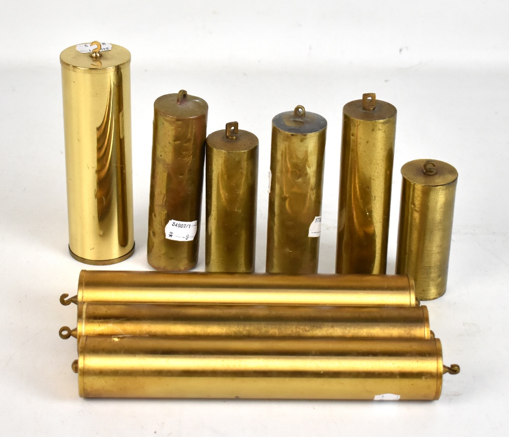 Nine assorted wall clock weights.