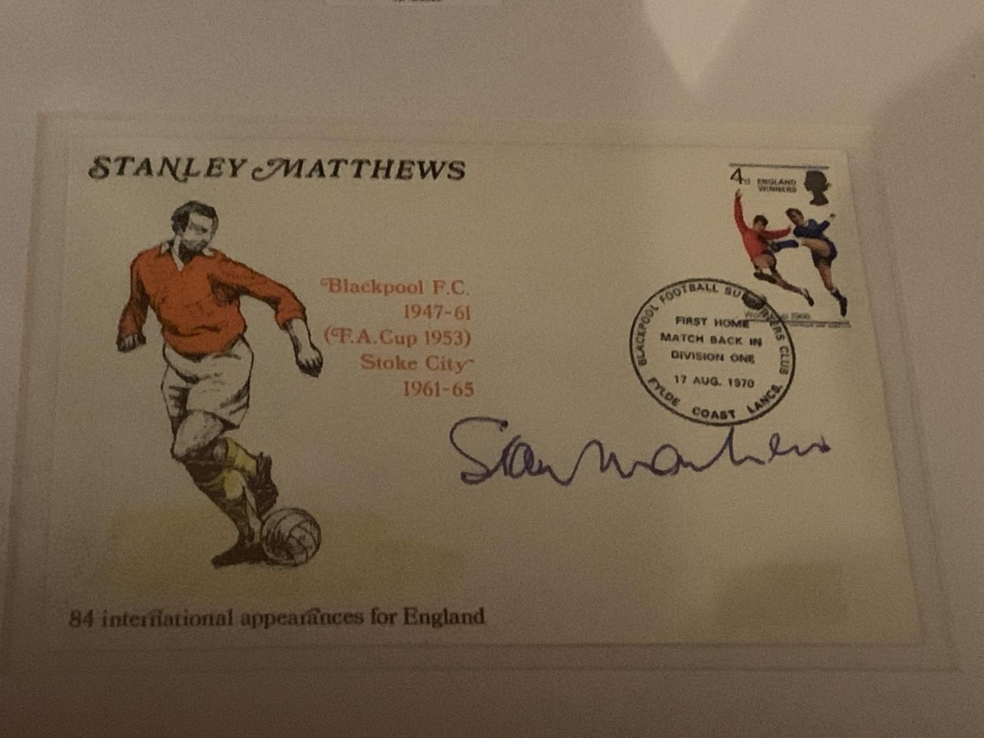 A SIR STANLEY MATTHEWS SIGNED COMMEMORATIVE POSTCARD AND STAMP IN A MOUNT