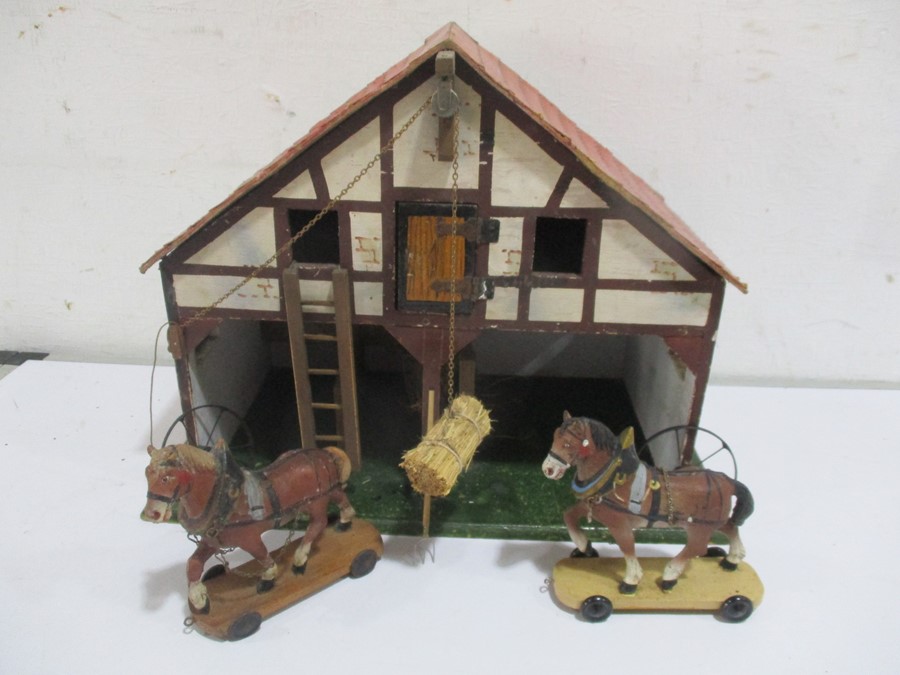 A wooden and card Elastolin stable with two cart horses, hay manger ...