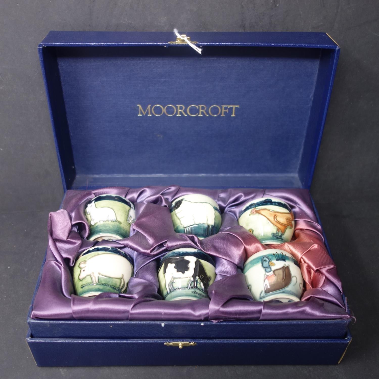 A boxed set of 6 Moorcroft egg cups, with farmyard animal design, by ...