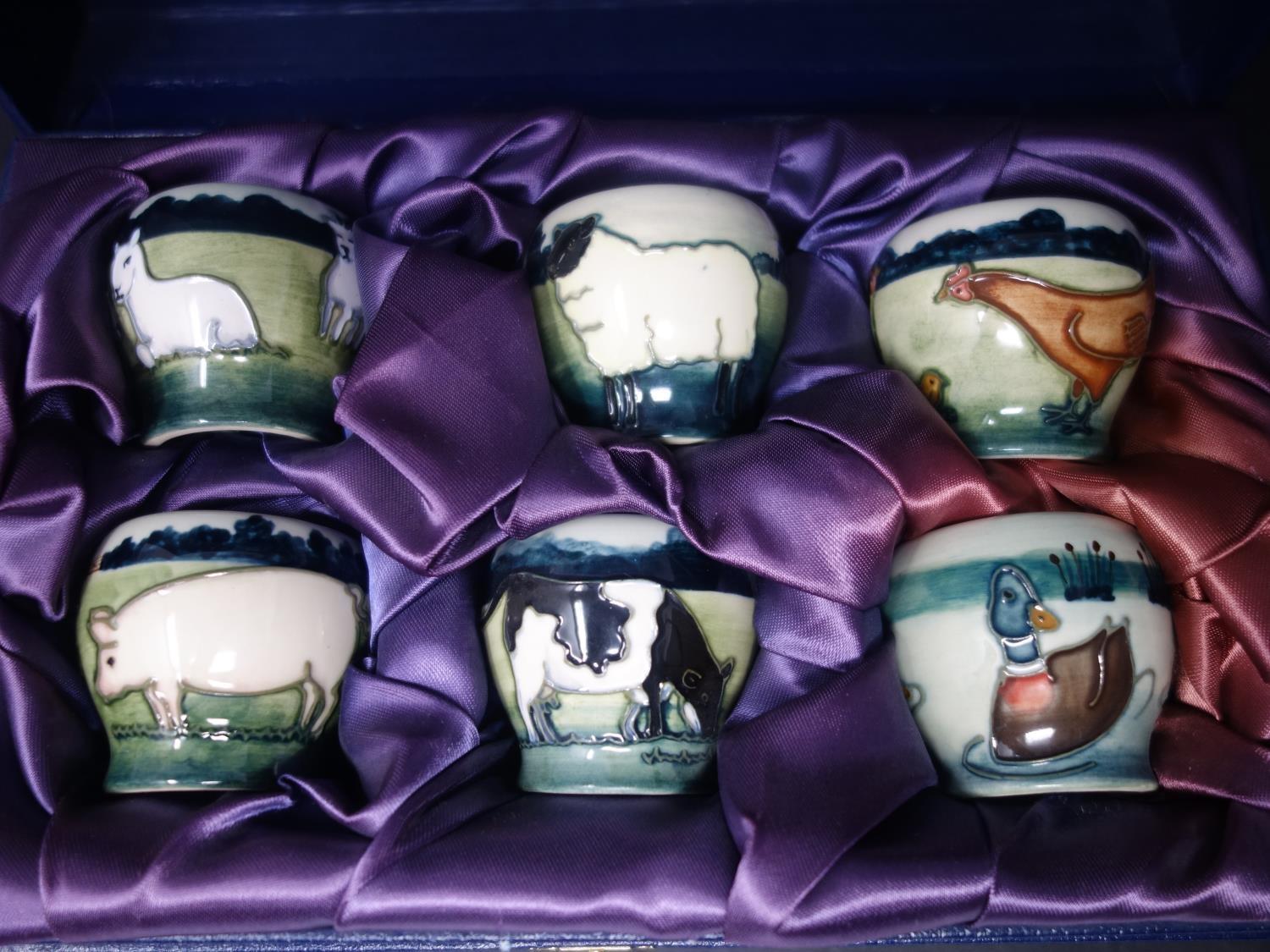 A boxed set of 6 Moorcroft egg cups, with farmyard animal design, by ...