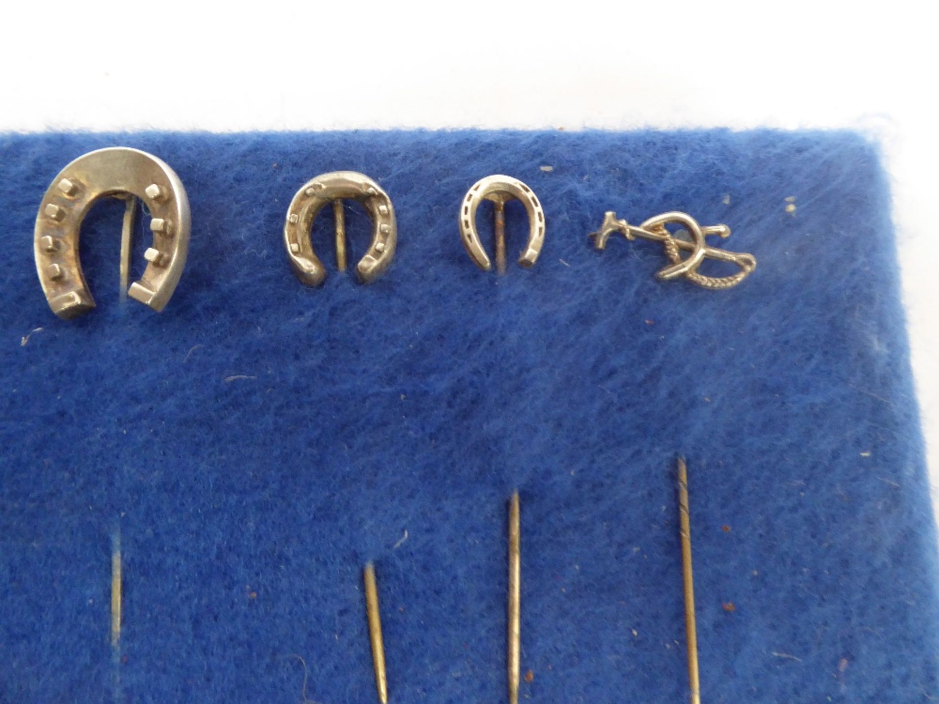 11 silver hunting stock pins, one of which is jet Estimate £60-70