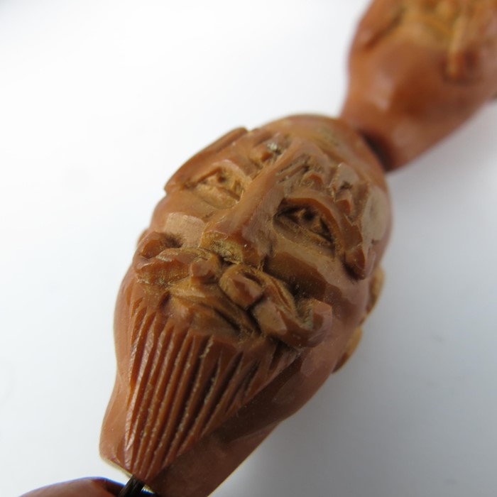A Chinese carved nut string of beads, each modelled as one of the ...