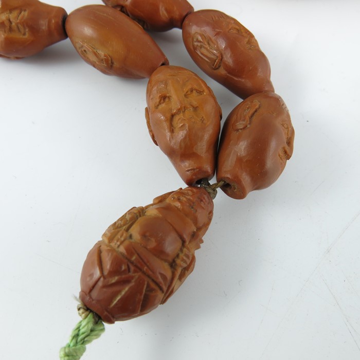 A Chinese carved nut string of beads, each modelled as one of the ...