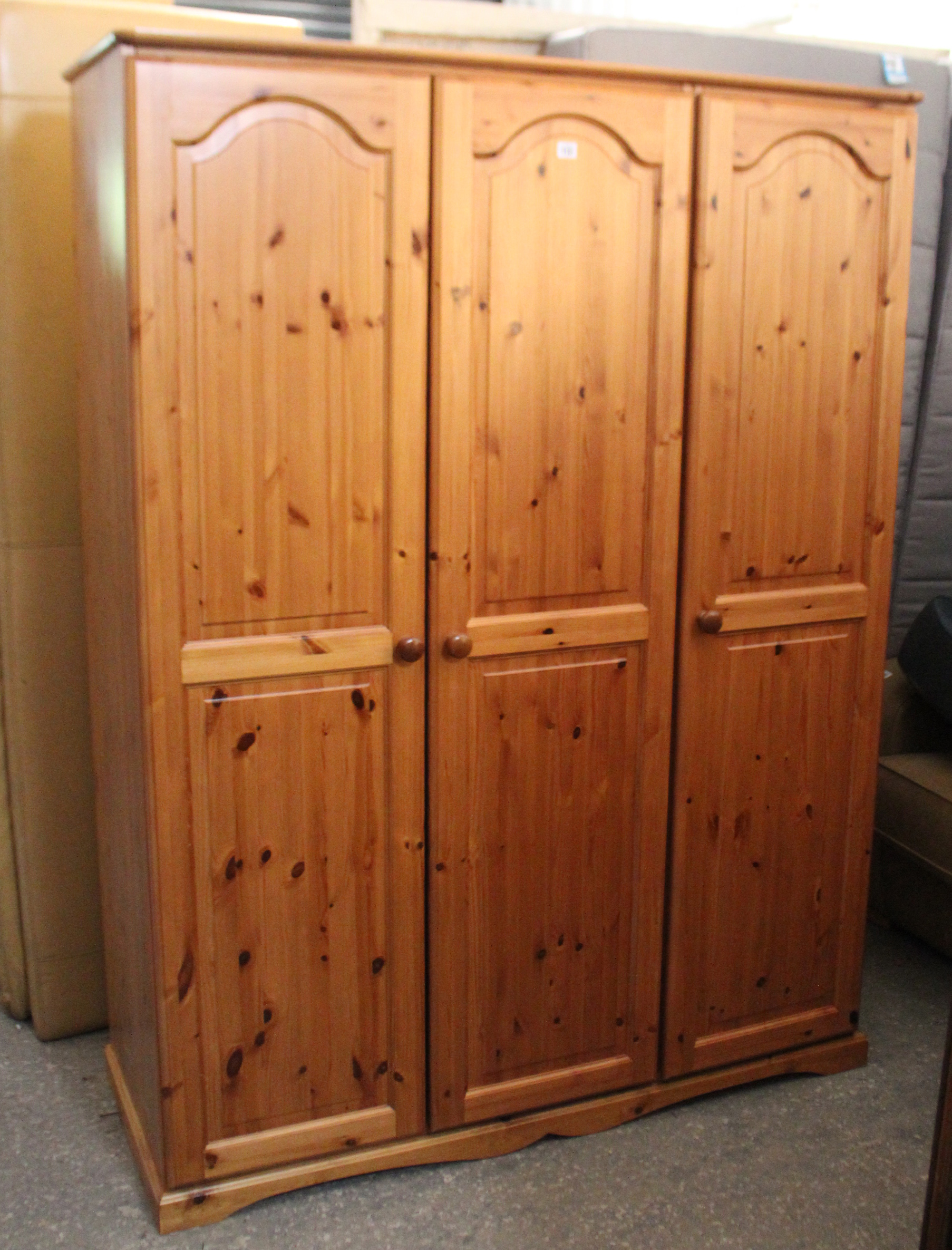A pine wardrobe with moulded cornice, enclosed by six fielded panel ...