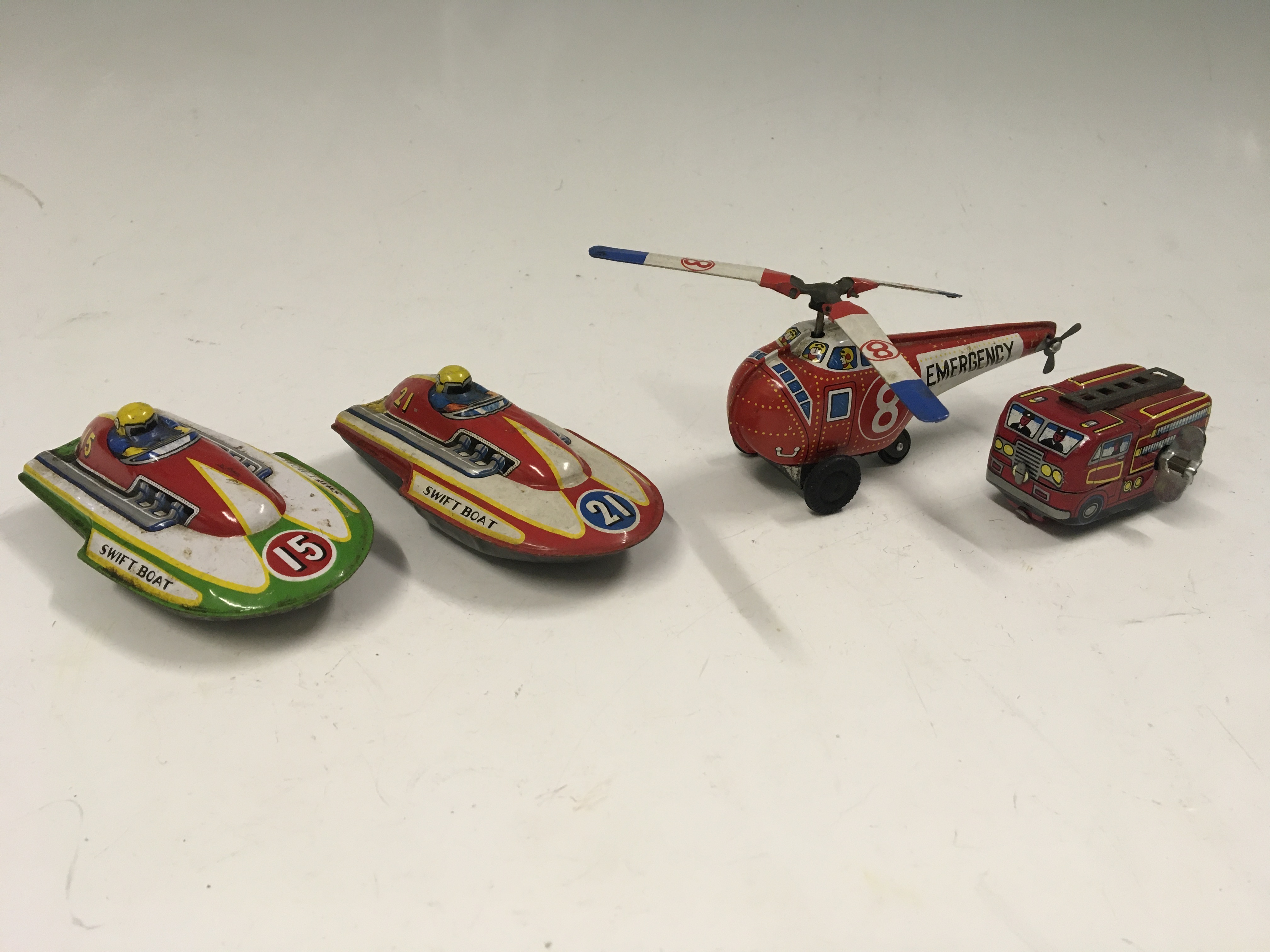 Four Japanese tinplate clockwork toys, including two Swift Boats 15 and ...