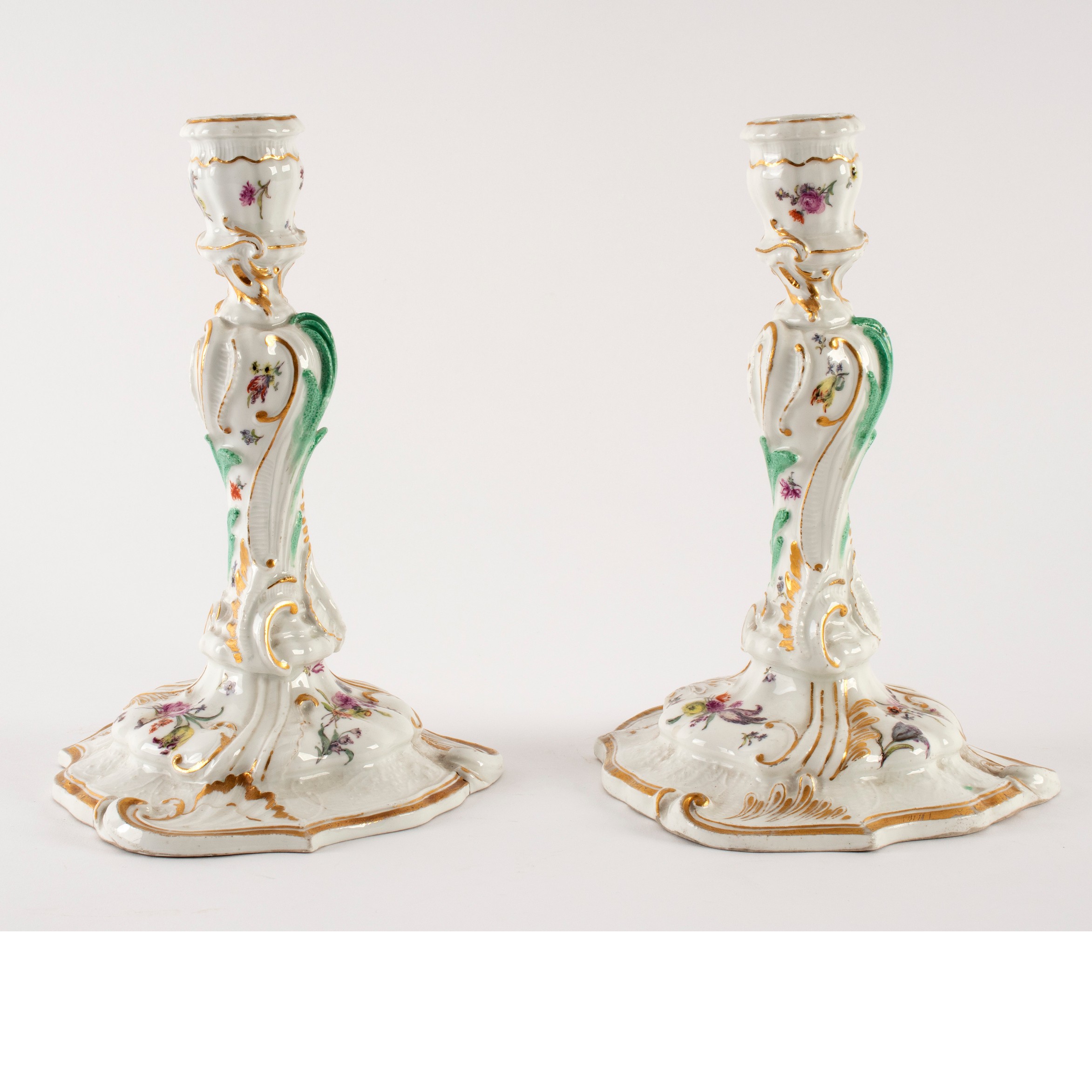 A pair of Meissen porcelain table candlesticks, leaf moulded and of ...