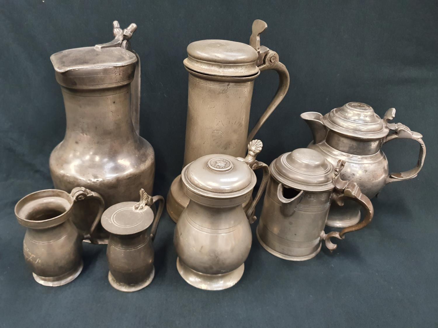 Antique pewter flagons and lidded vessels.